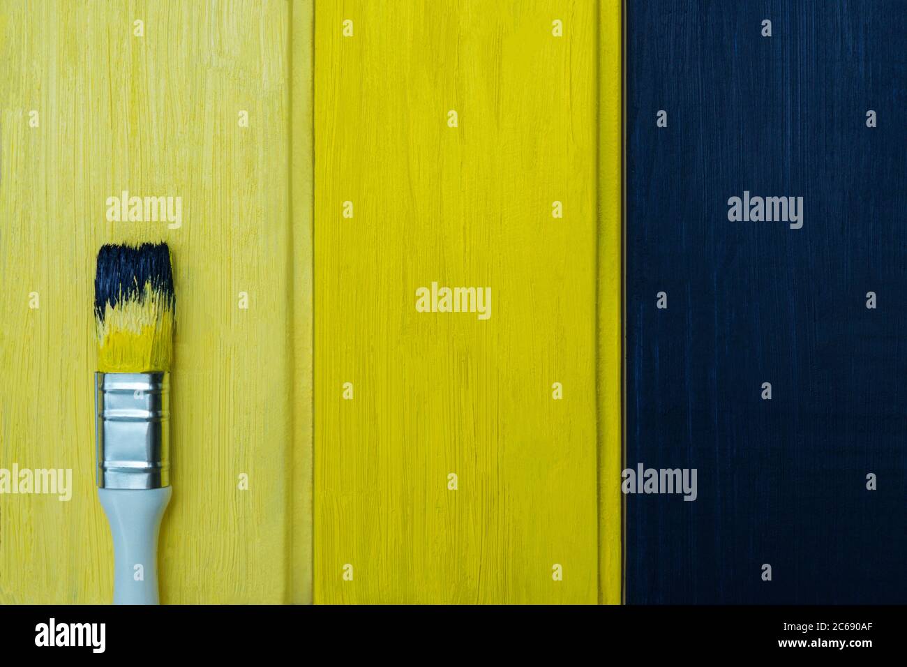 The board is painted blue and yellow colors and a brush with blue ...