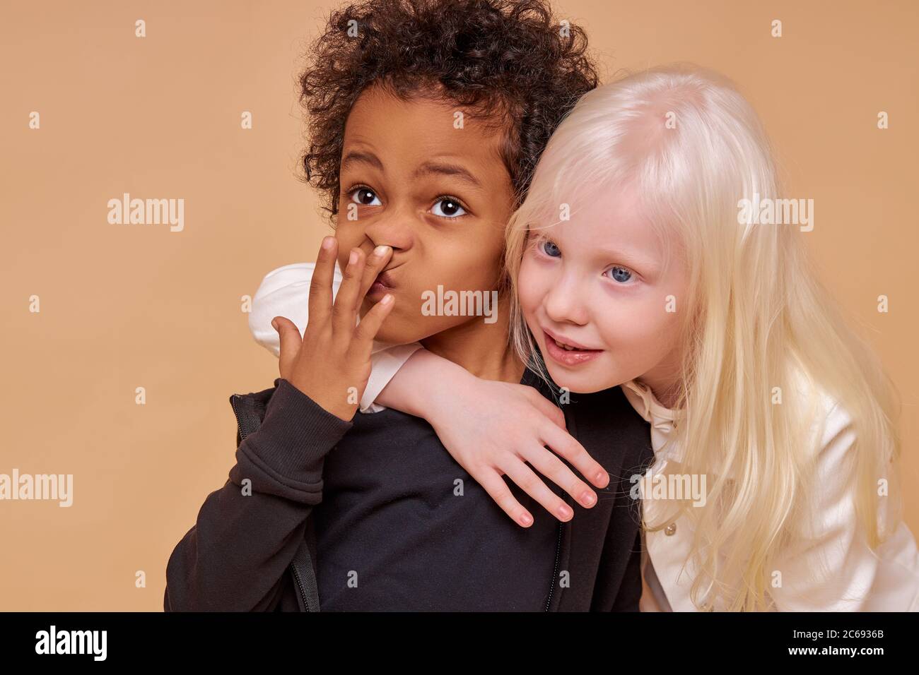 friendly albino girl hug multiracial boy from back, african boy at a ...