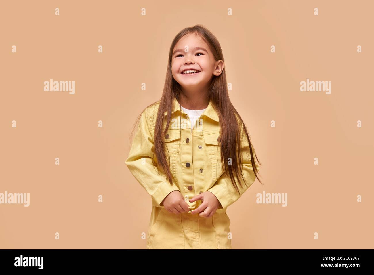 portrait of caucasian open-minded child girl isolated over beige ...