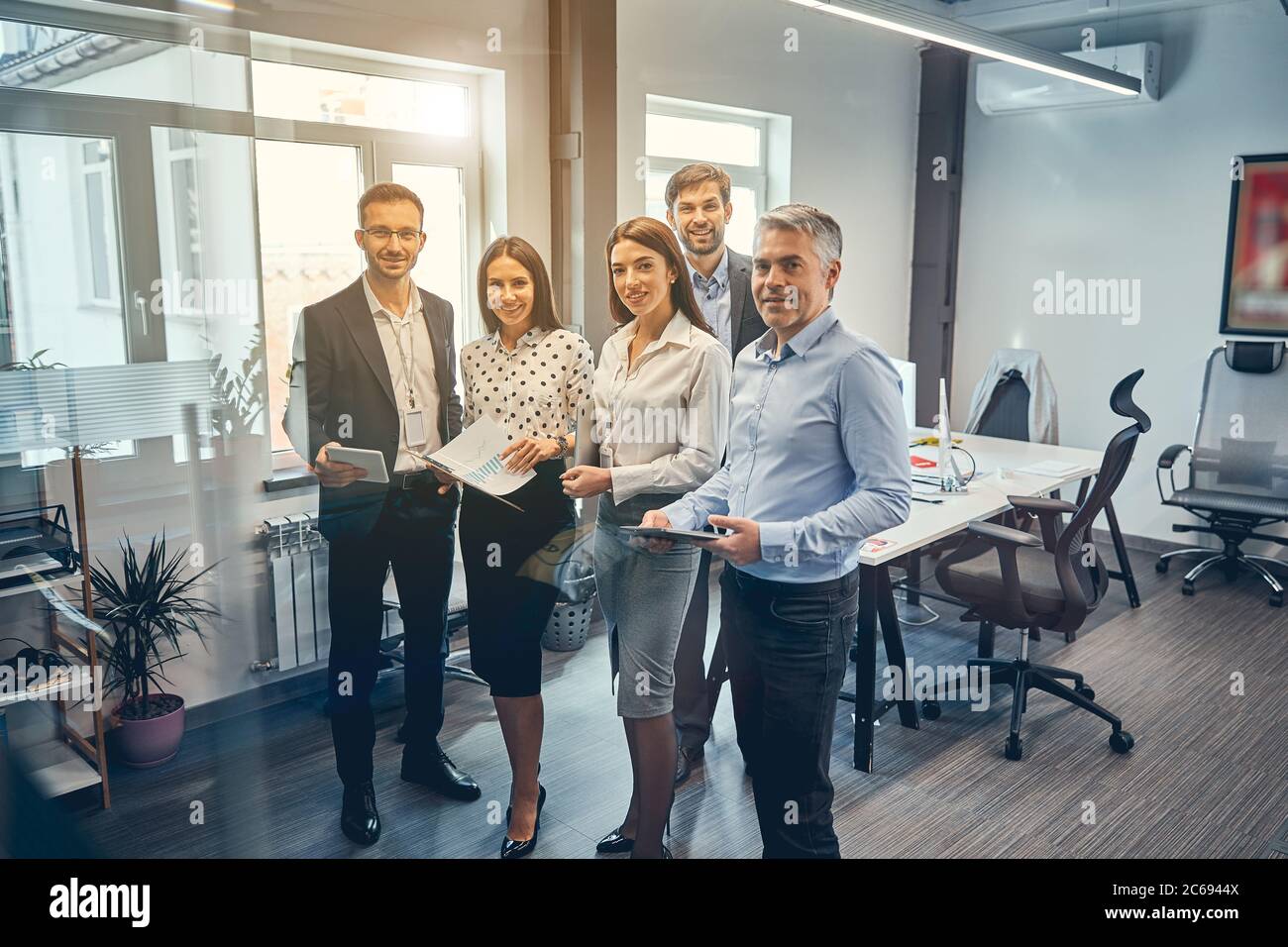 Happy friendly smart people standing in the modern interior office ...