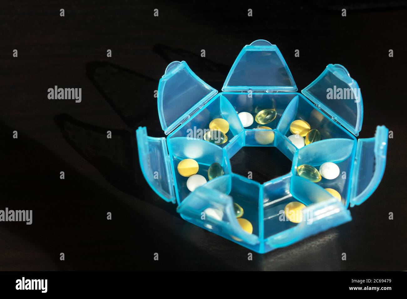 Days of the week pill box as corona symbol on black. Sunshine and ...