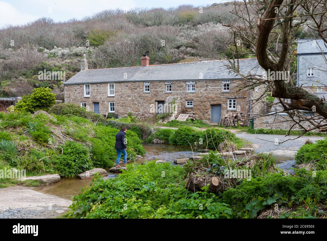 Woman crossing over the Penberth River on stepping stones , Penberth ...