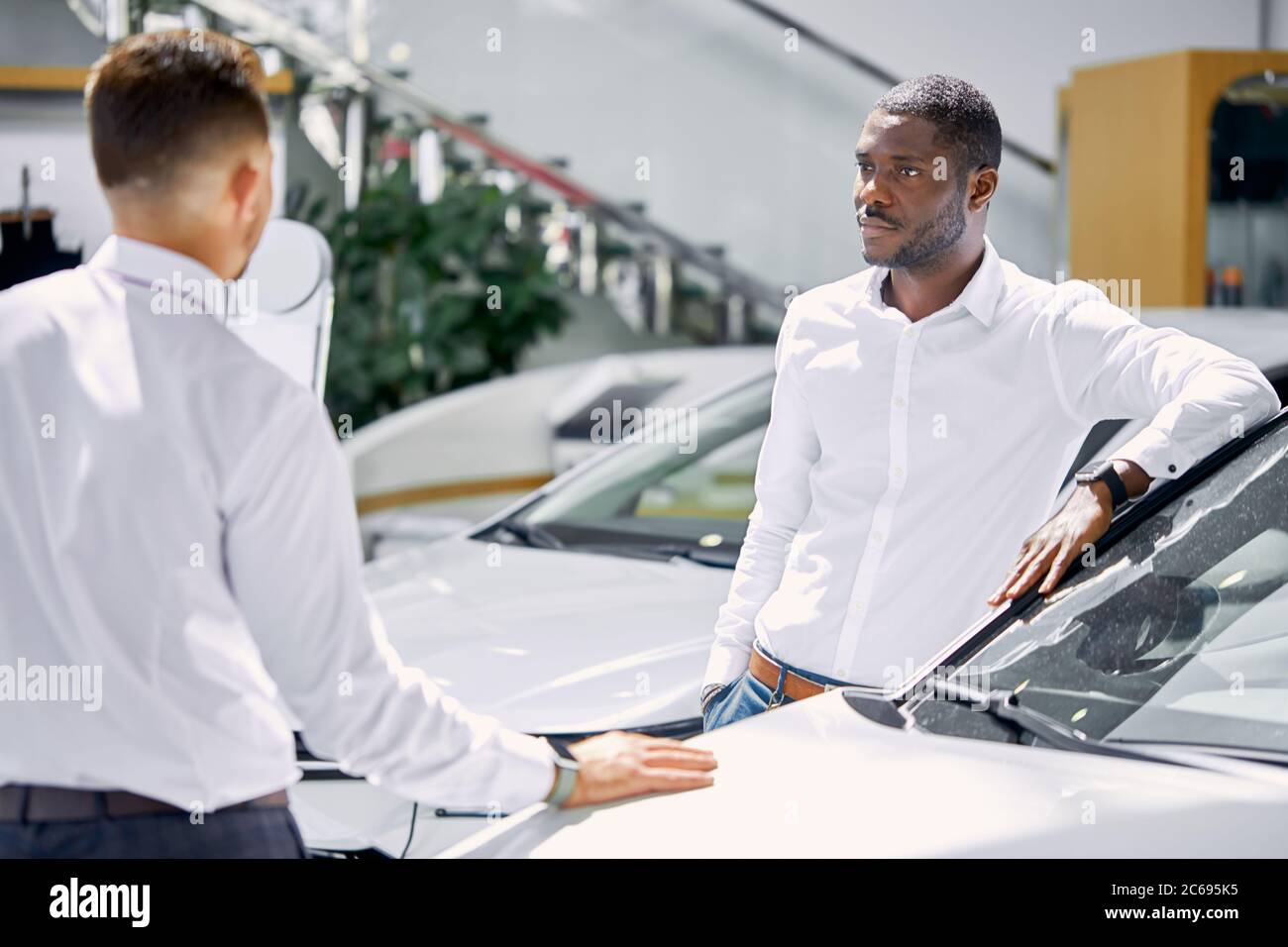 confident professional salesman talk about characteristics of car to ...