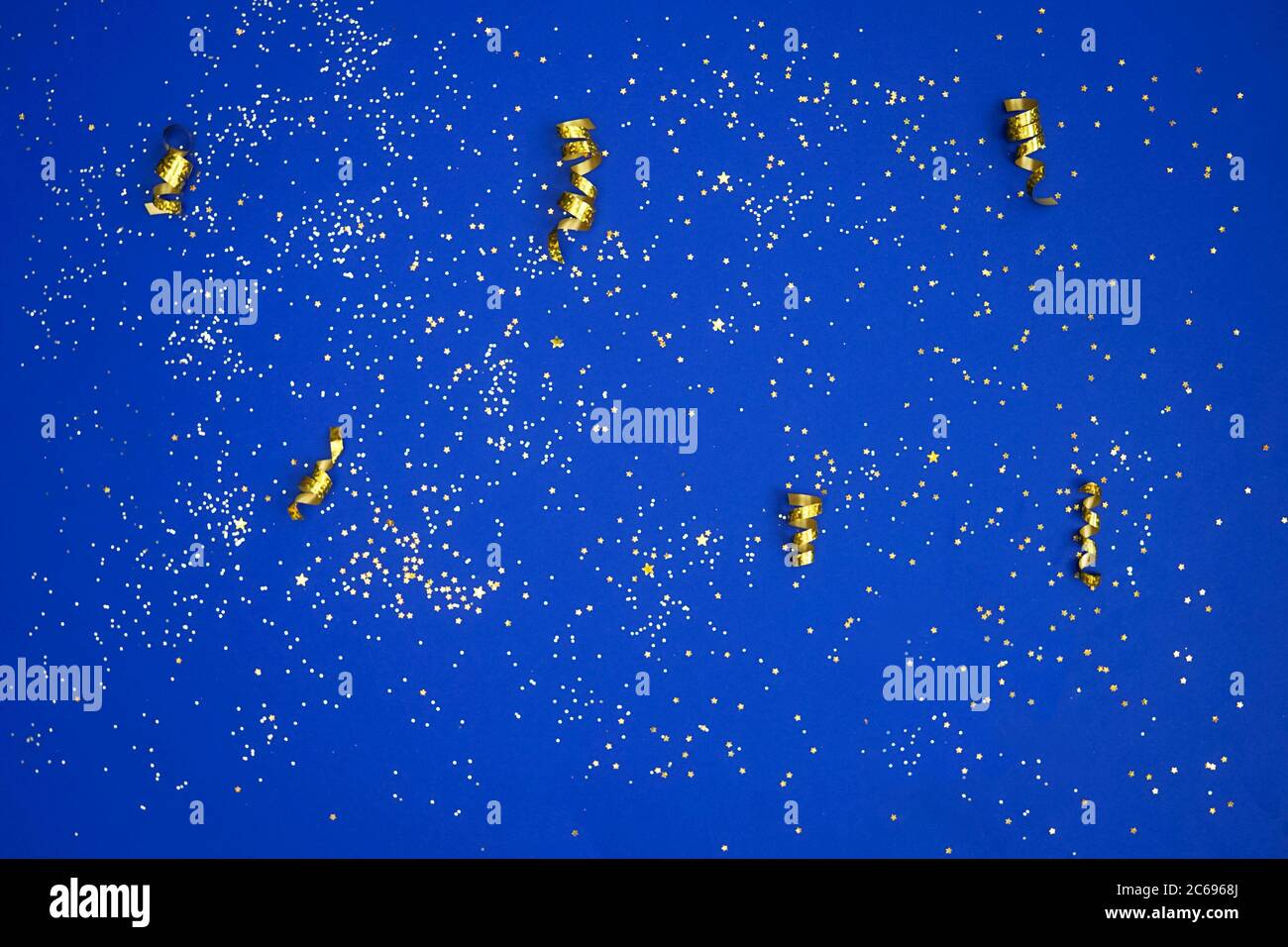 Golden decorations and sparkles on bright blue background. As fireworks ...