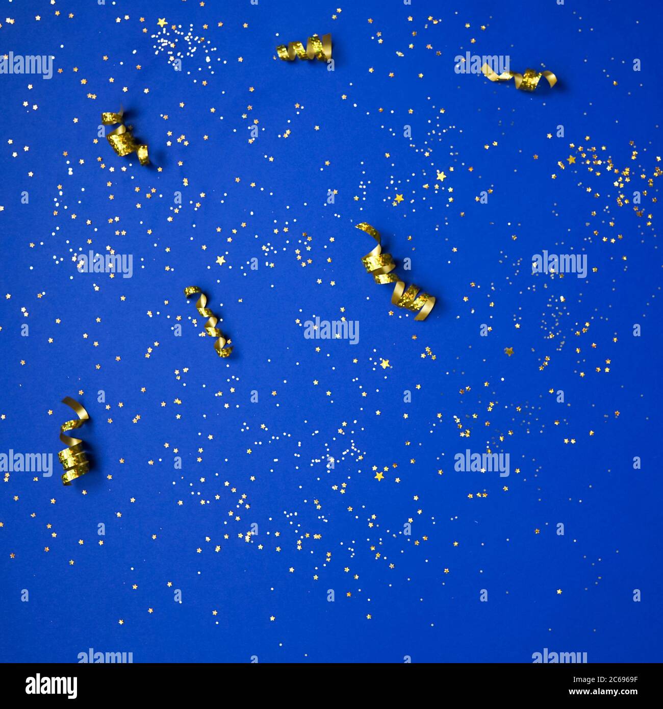 Golden decorations and sparkles on bright blue background. As fireworks ...