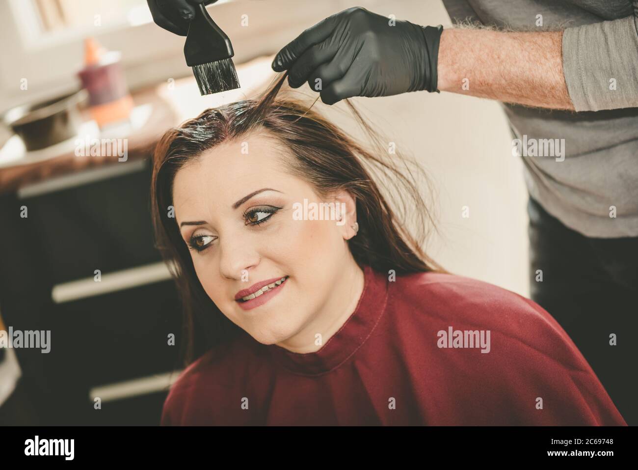 Hairdresser coloring female client hair Stock Photo - Alamy