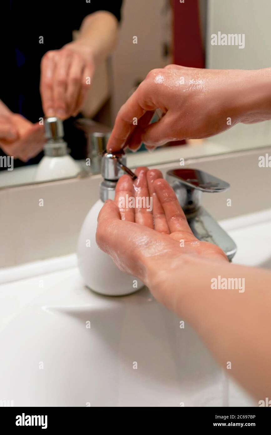 Washing of hands. Push soap from white bottle Stock Photo - Alamy