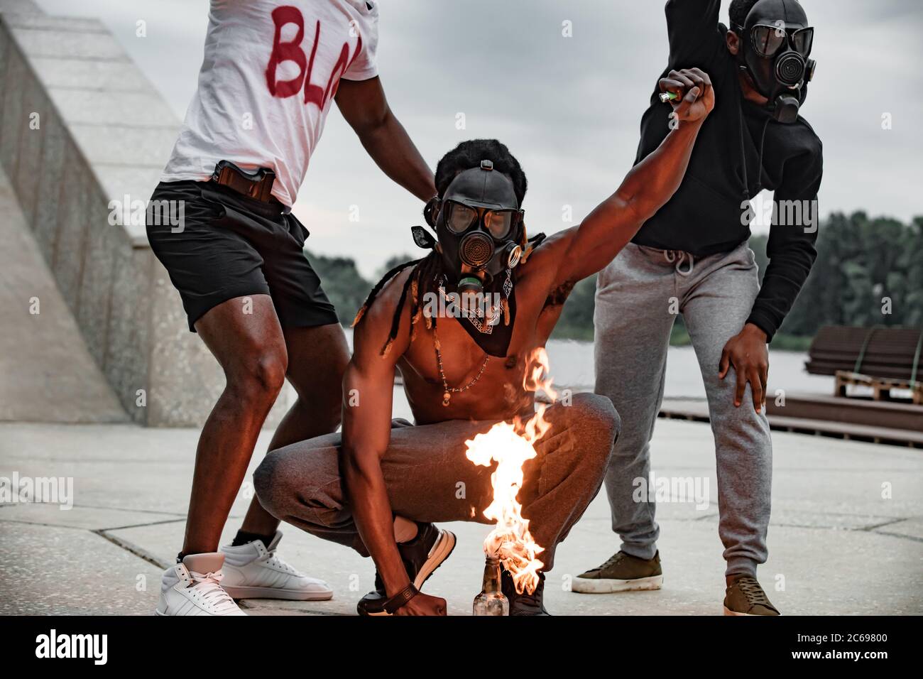 young aggressive africanamerican men set fire on bottles in the streets ...