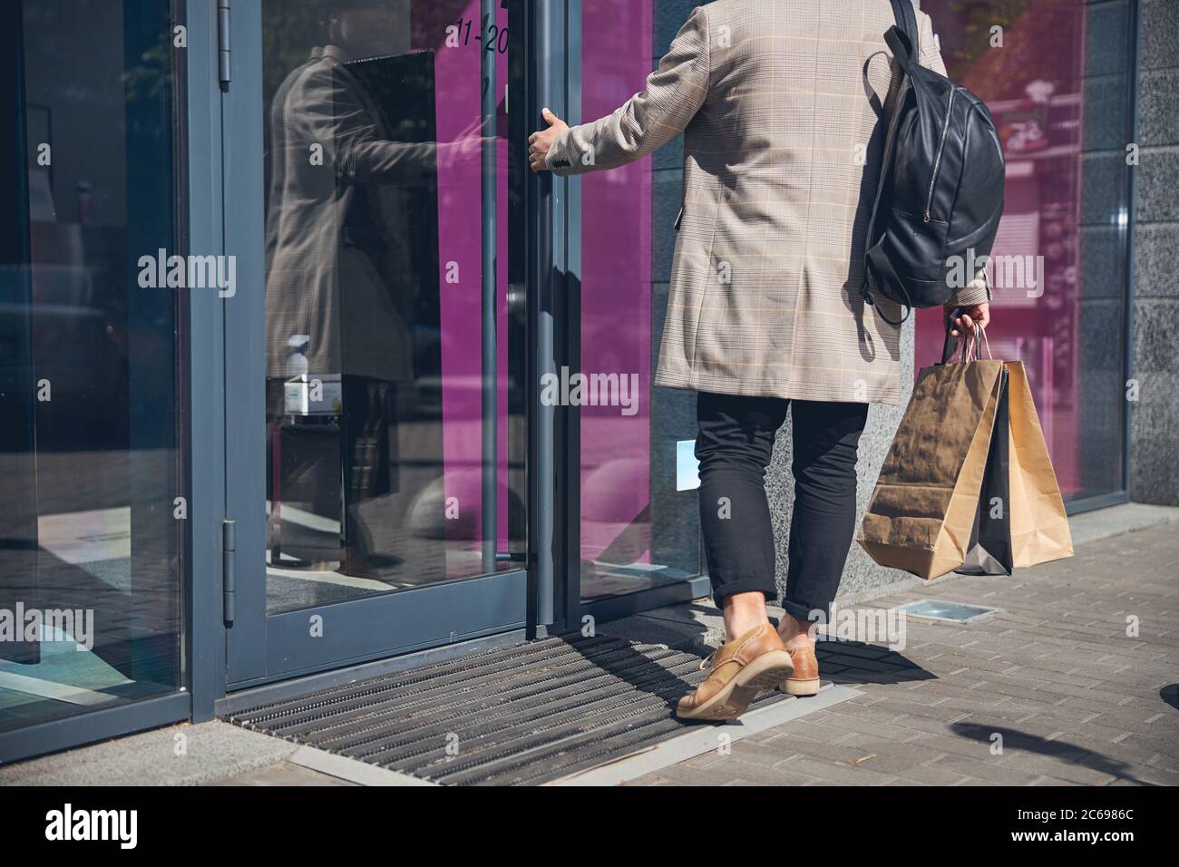 Stylish young man walking into the store Stock Photo - Alamy