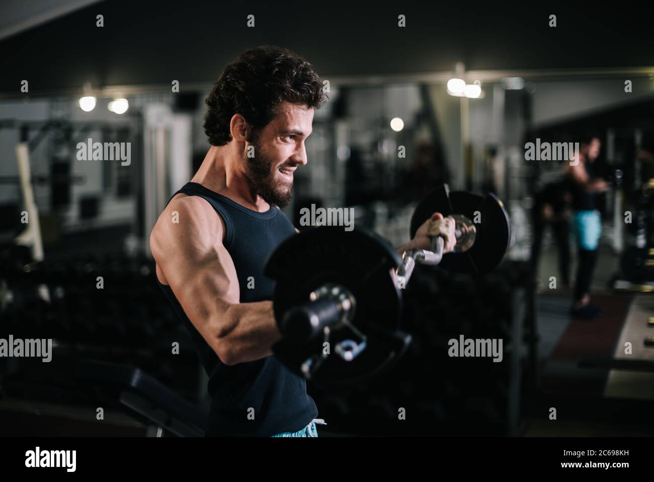 Side view of sportive bearded young man with muscular body working out ...