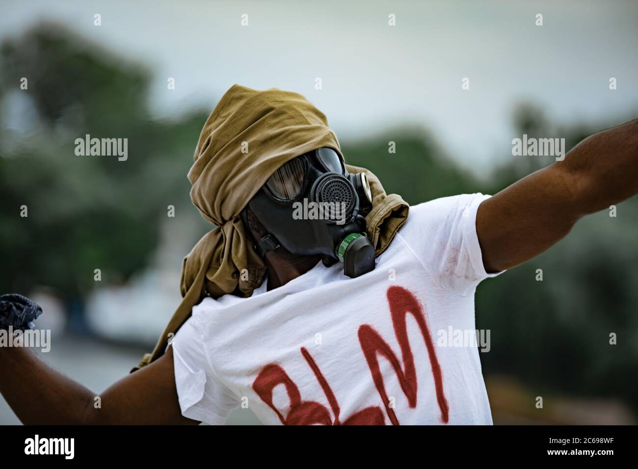 young angry black man in gas mask going to throw a fire bottle, man ...
