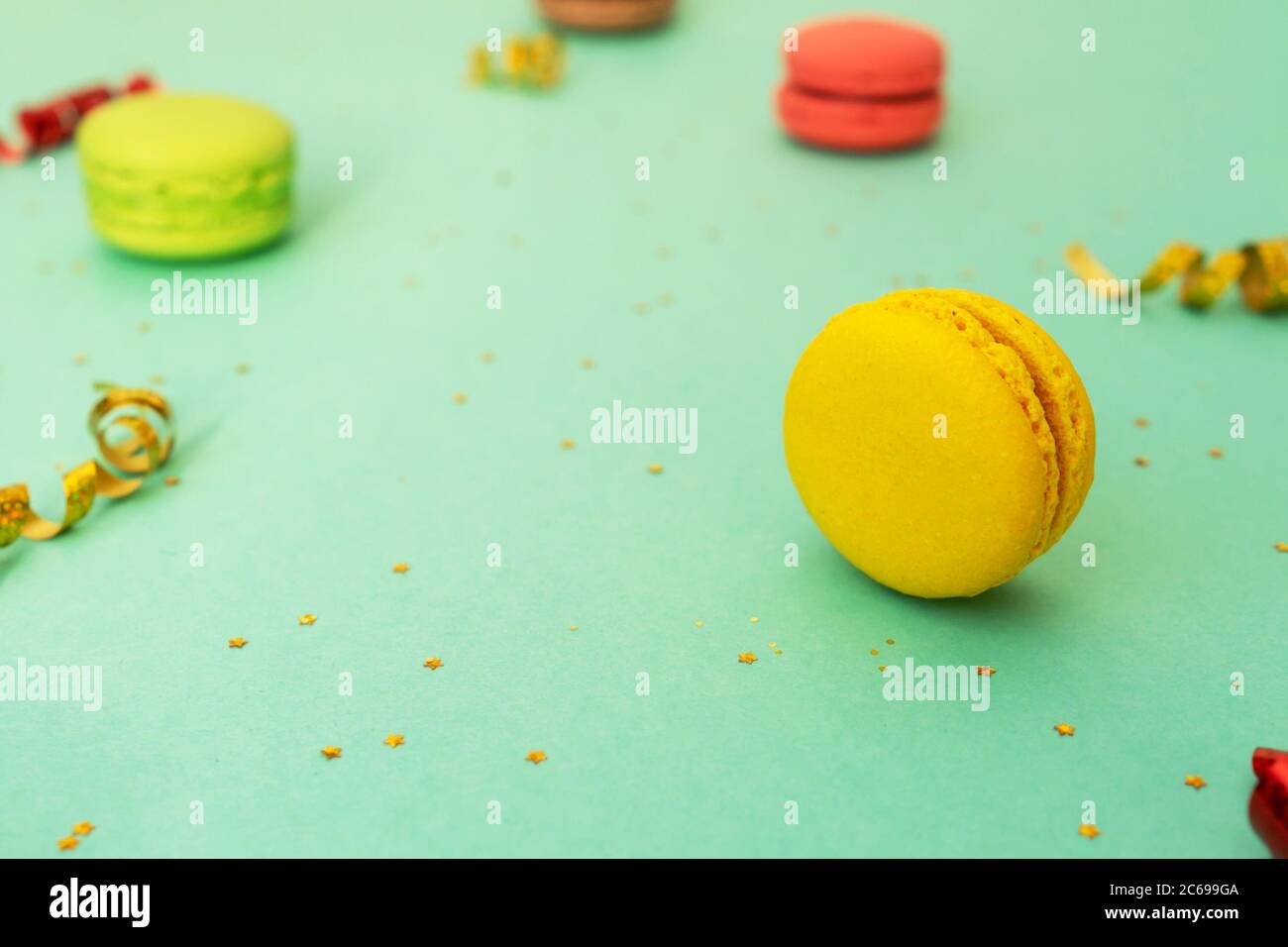 Sweet and colourful french macaroons on turquoise background with ...