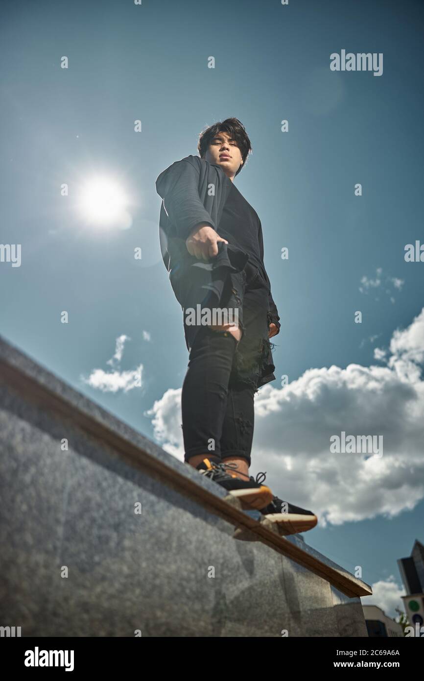 Stylish young man standing under beautiful sky Stock Photo - Alamy