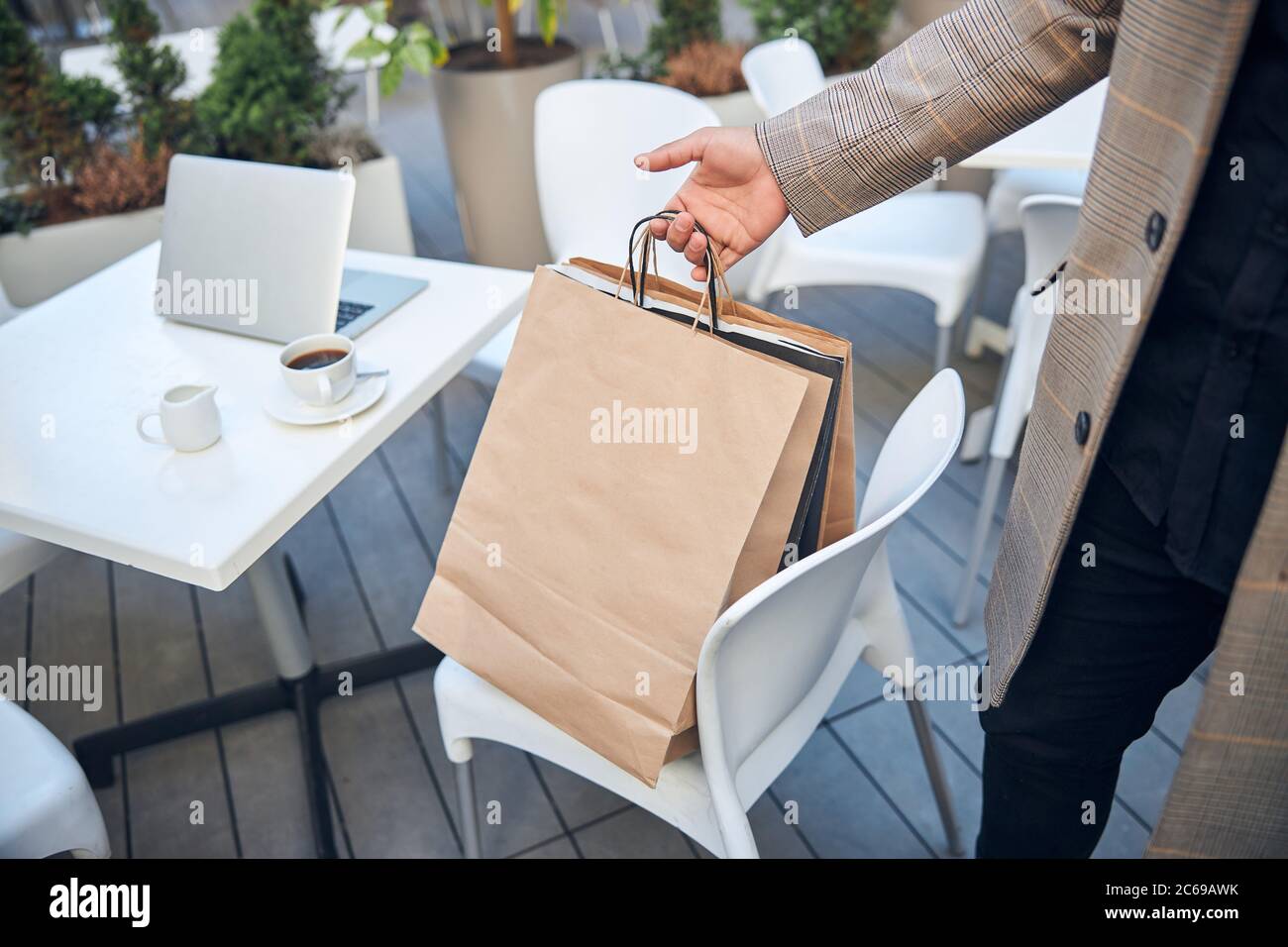 Young man grabbing shopping bags in outdoor cafe Stock Photo - Alamy
