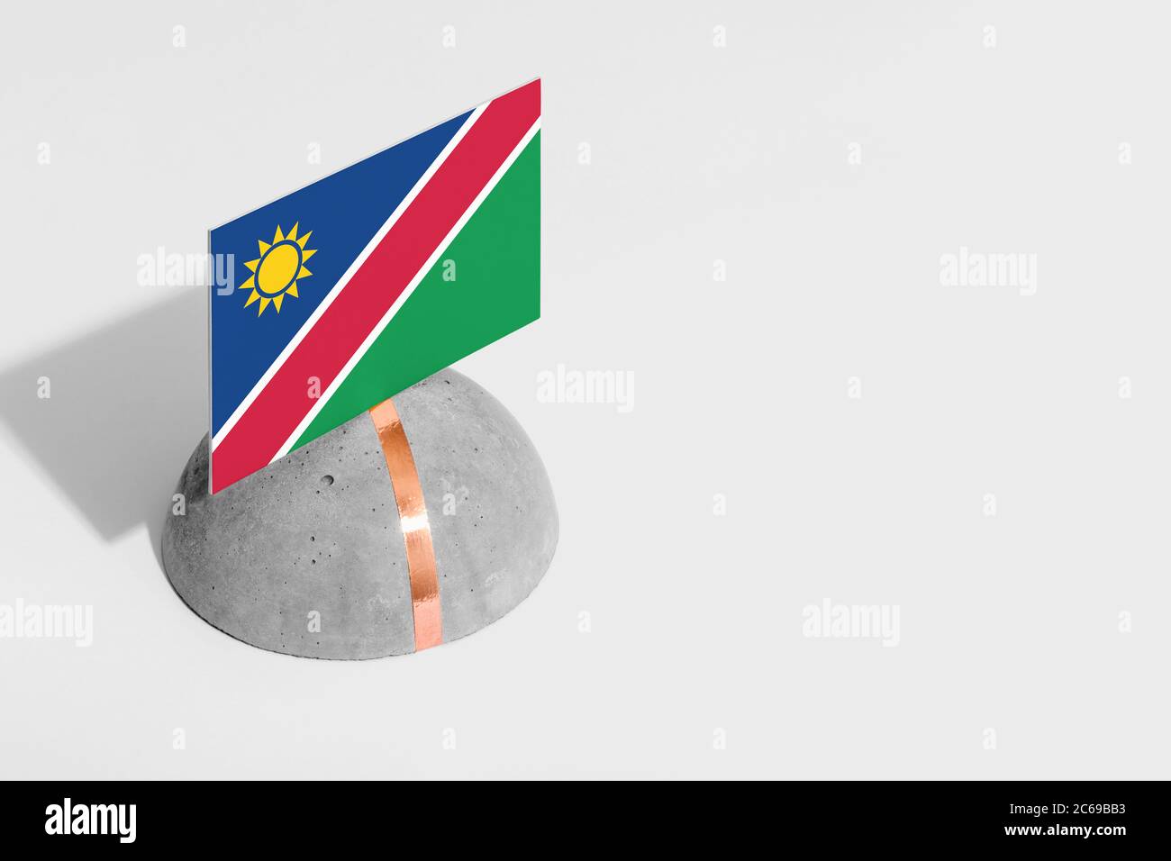Namibia flag tagged on rounded stone. White isolated background. Side ...