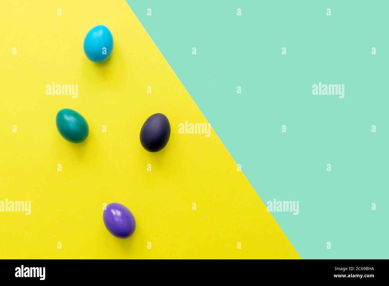 Color easter eggs over mint and yellow backgrounds. Easter hipster ...
