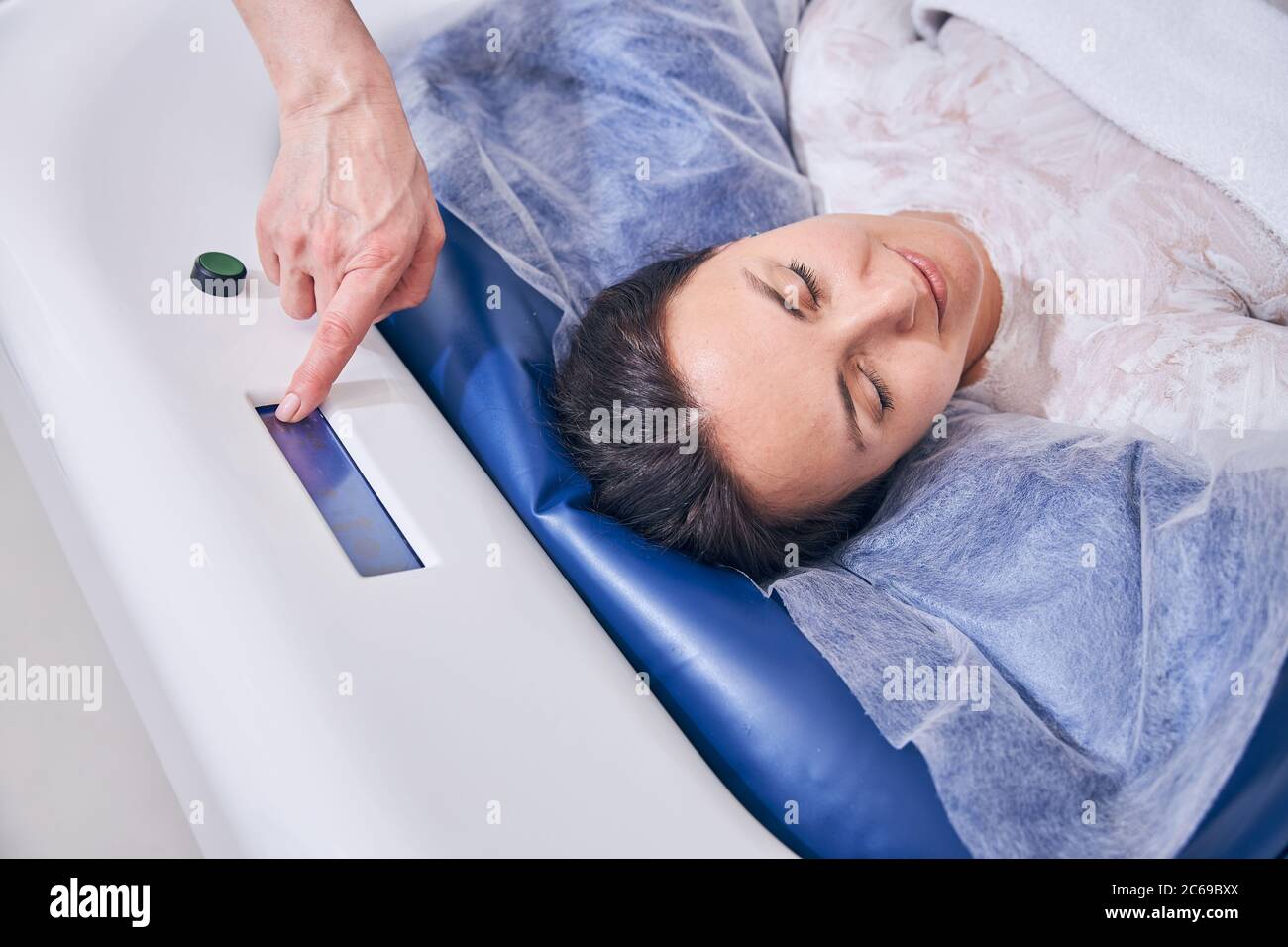 Beautician switching on the floating device in spa salon Stock Photo ...