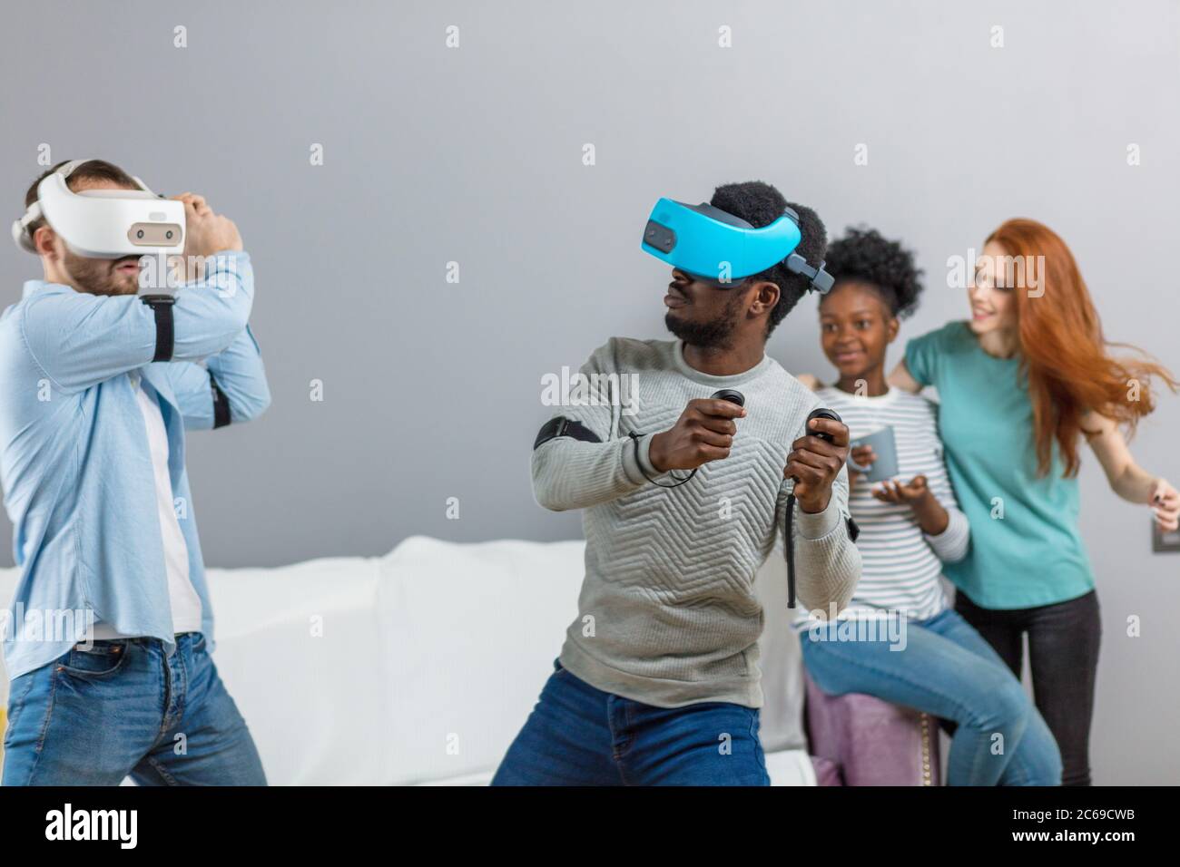 Group of multiracial male amd female students playing virtual game ...