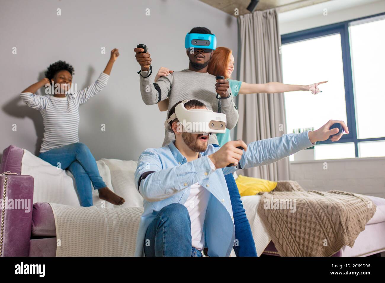 Group of multiracial male amd female students playing virtual game ...