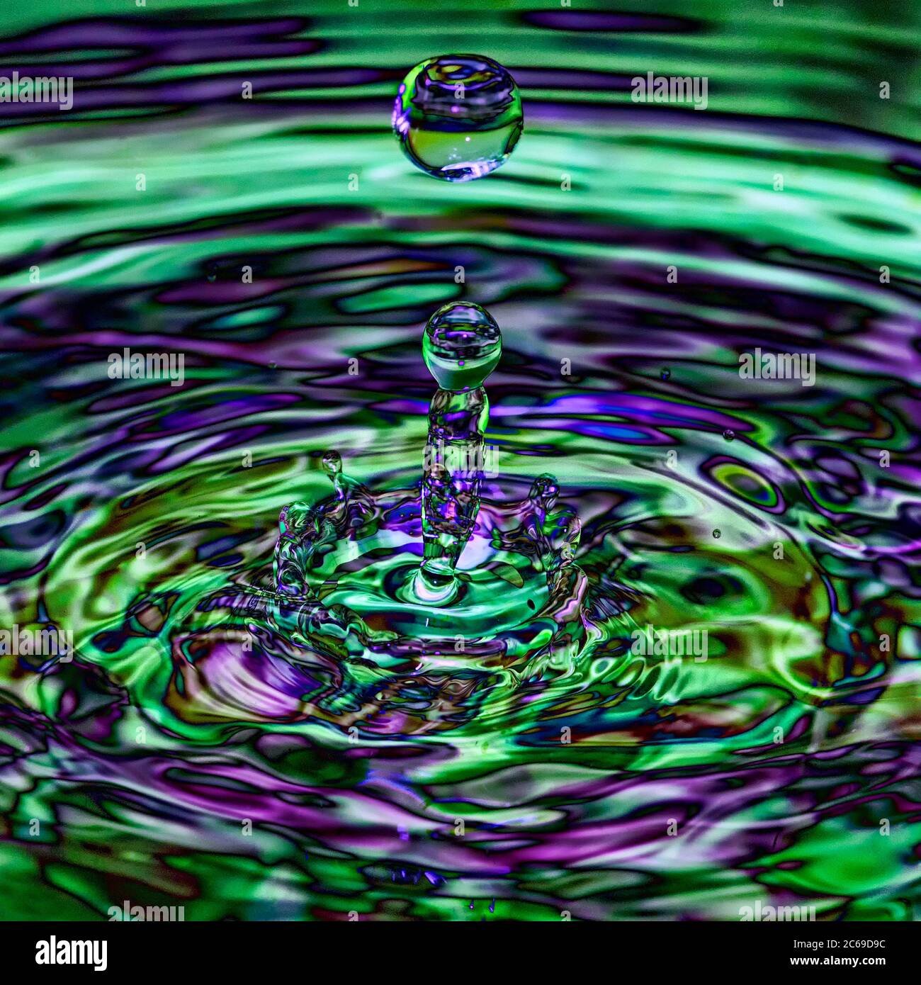 Water splash, droplet with a multi coloured blue green iridescent ...