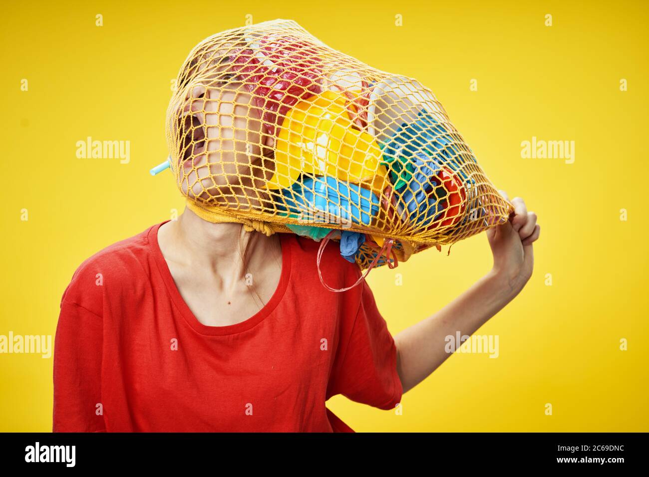 woman in a string bag with plastic objects choking on trash Stock Photo ...