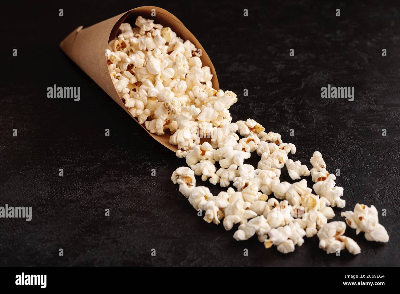 Popcorn in paper cone on black background. Top view, flat lay. Copy ...
