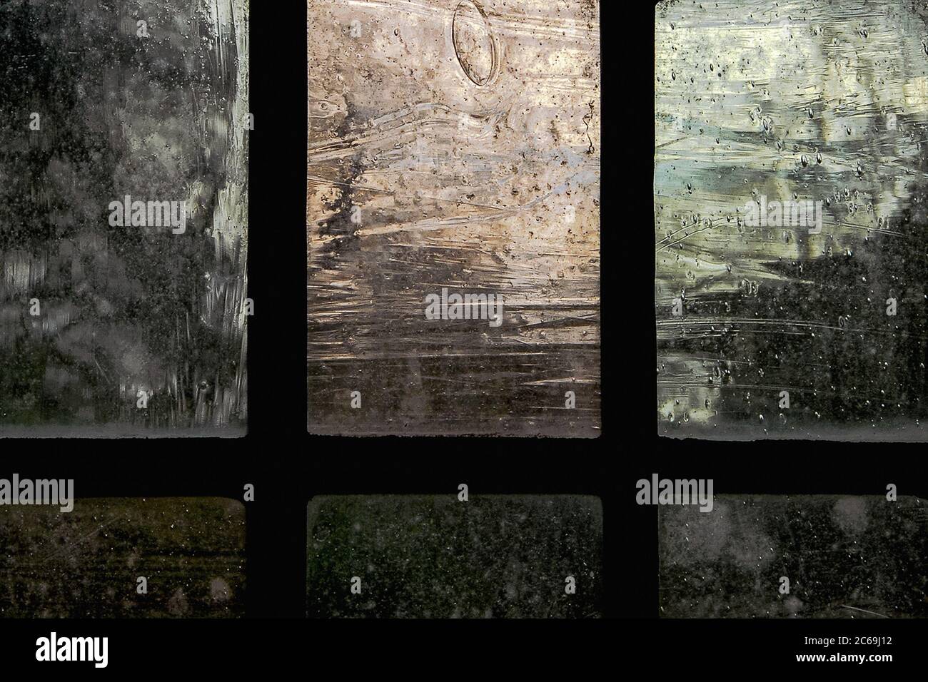 Tinted leaded lights of ancient handmade glass full of bubbles, ridges ...