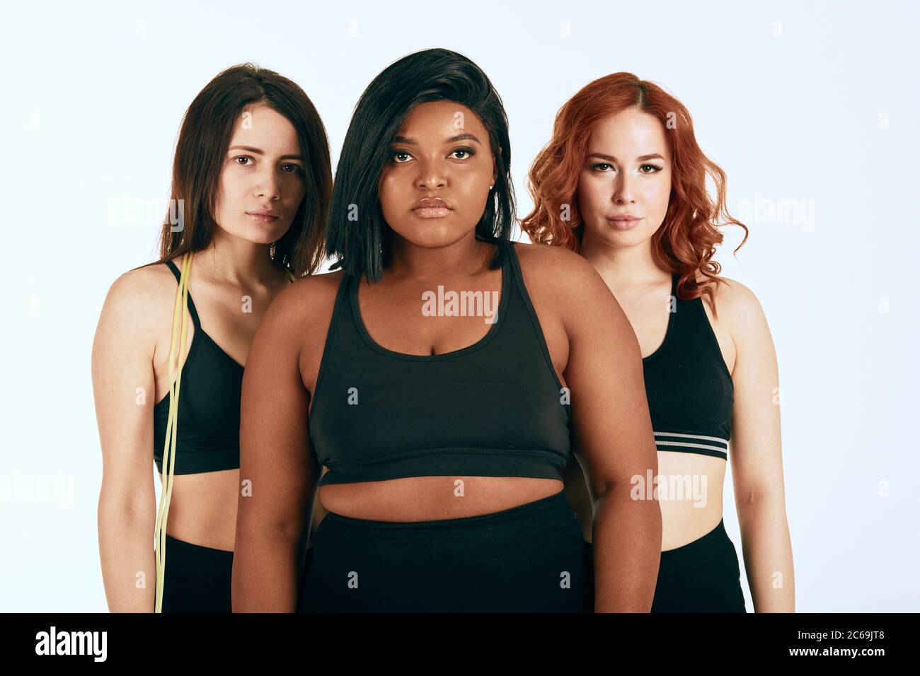 African gloomy overweight woman in company of two caucasian slim ...