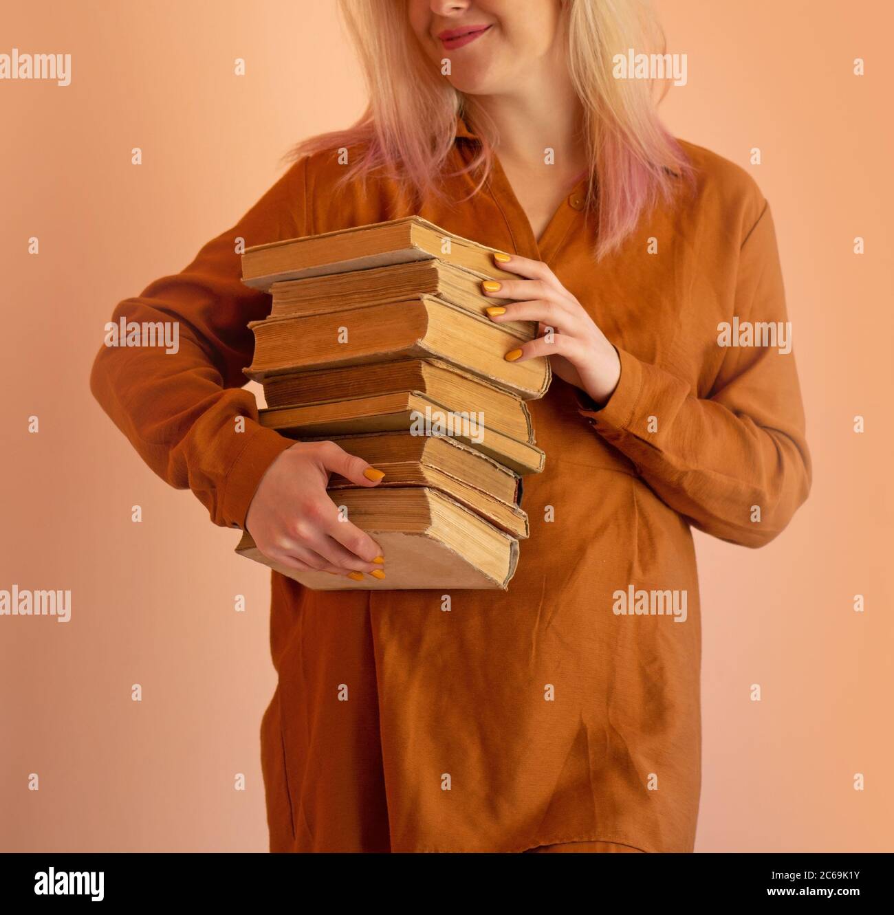 Happy casual girl holding stack color book. Student standing with books ...