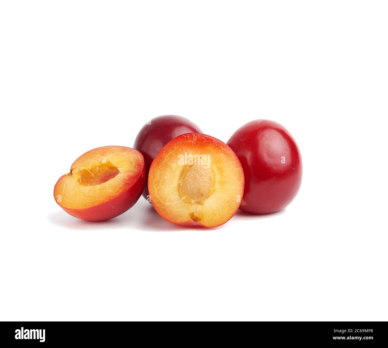 ripe red whole and halves of plum isolated on white background, close ...