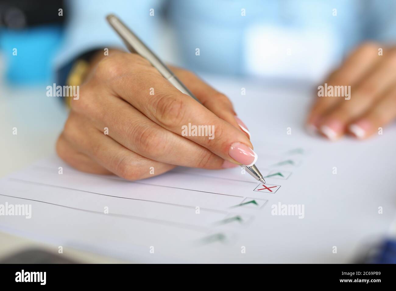 Woman fills out questionnaire by ticking document Stock Photo - Alamy