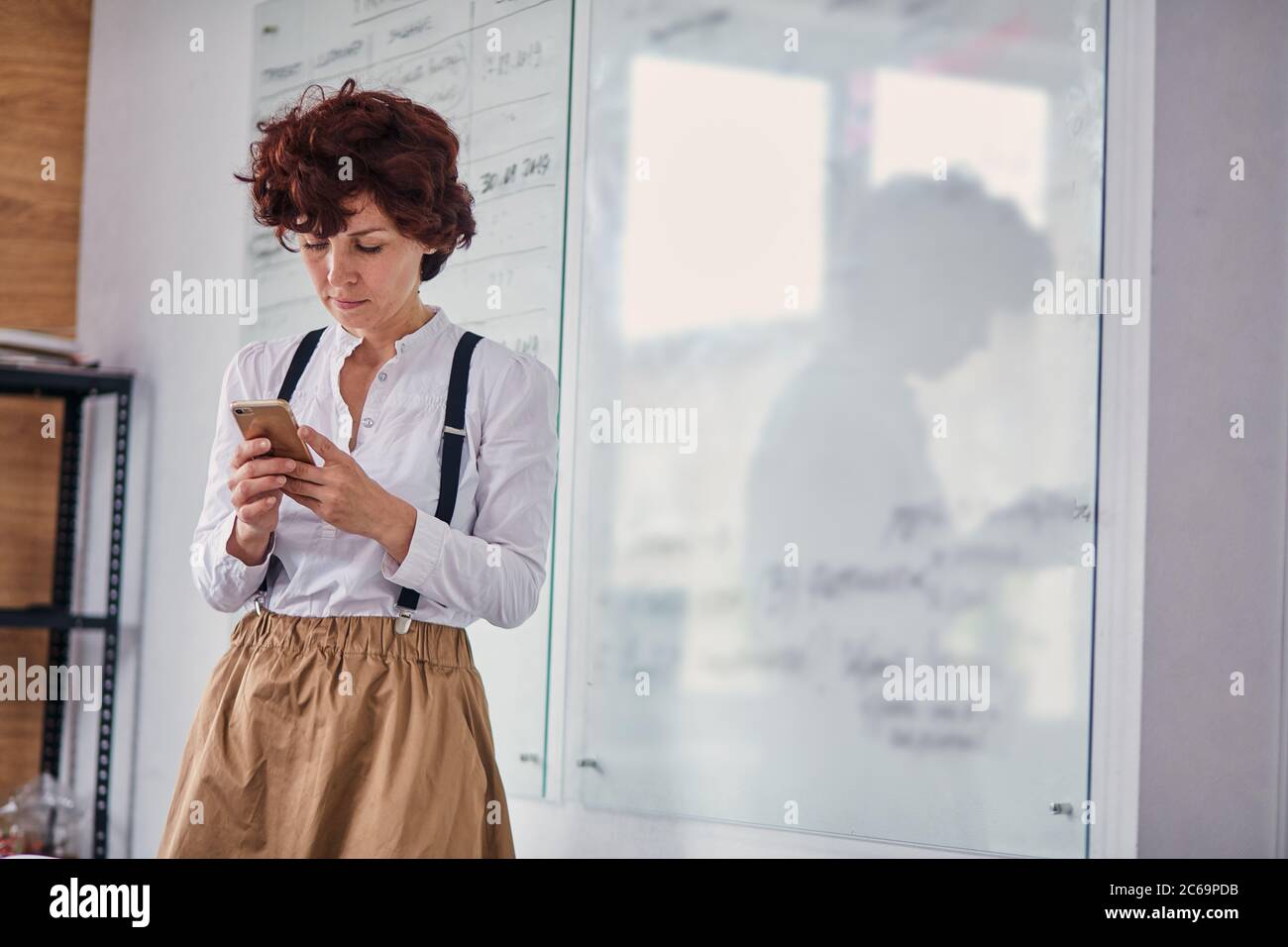 Using modern mobile phone during work in office, scheme board ...