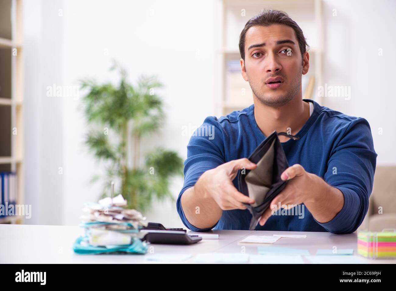 Young man in the budget planning concept Stock Photo - Alamy