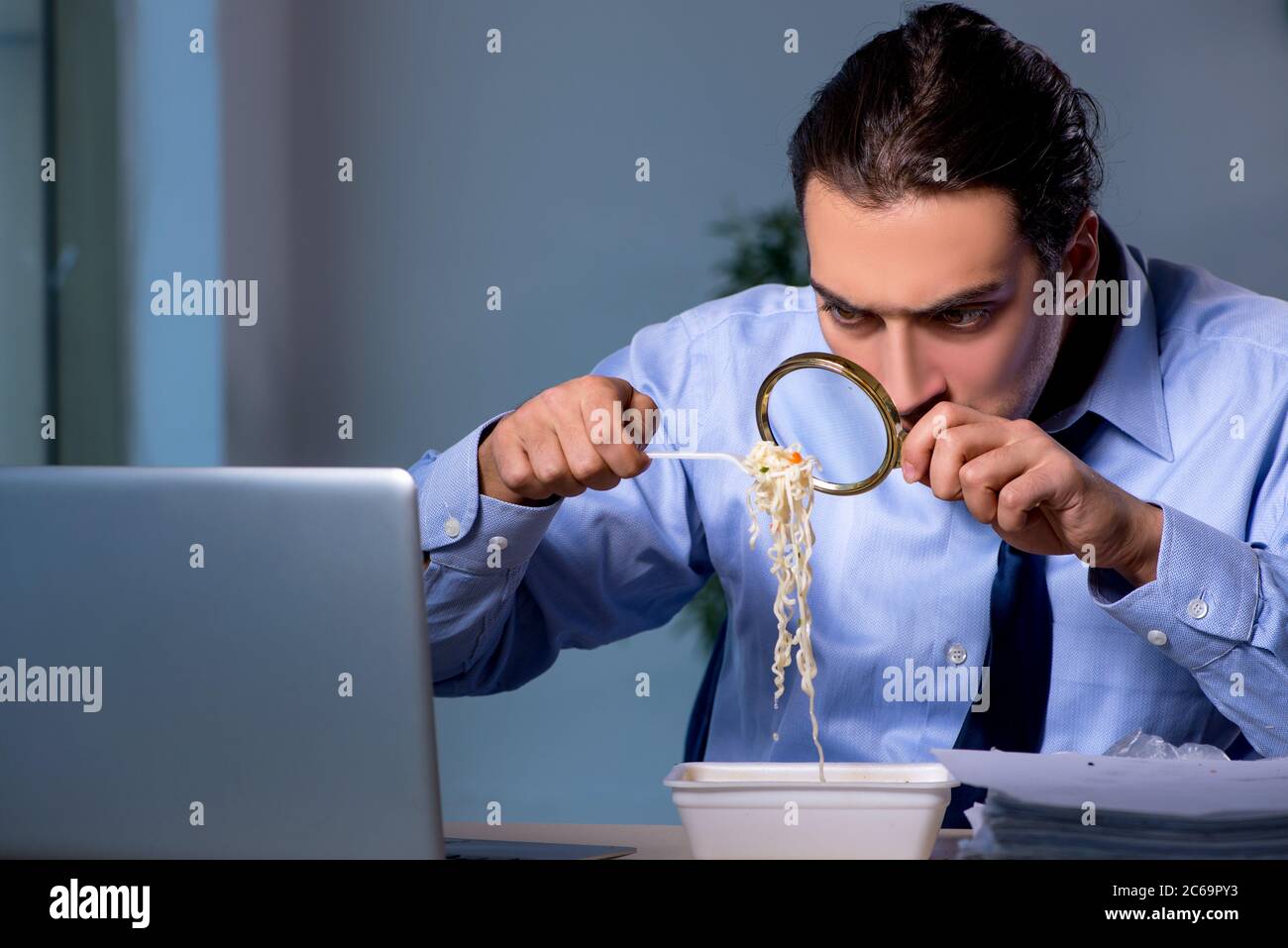 Hungry employee working late in office Stock Photo - Alamy
