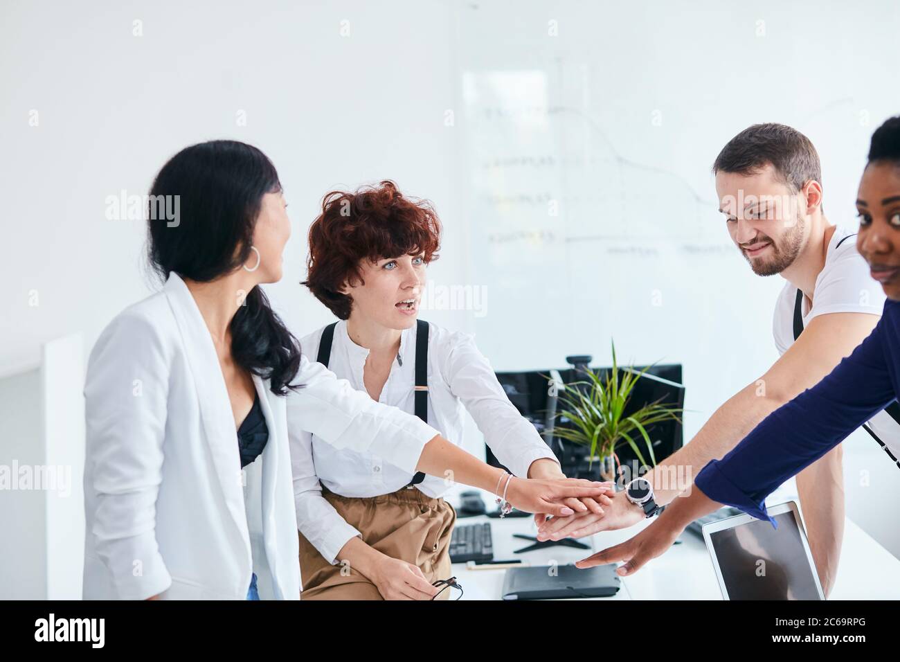 Successful joint work together of interracial team, sitting in white ...