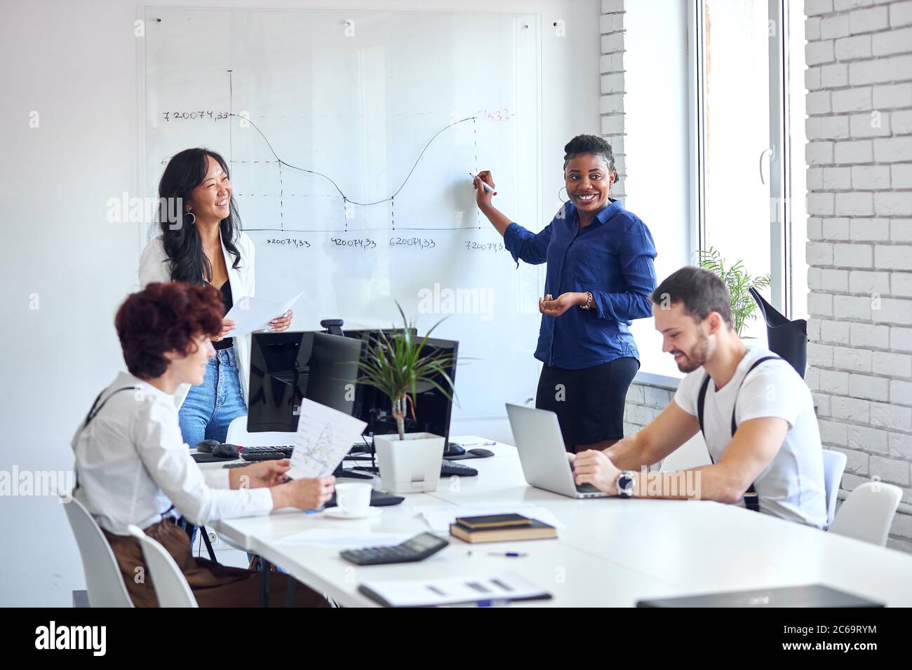 multi-ethnic team listen to presentation of african coach leader ...