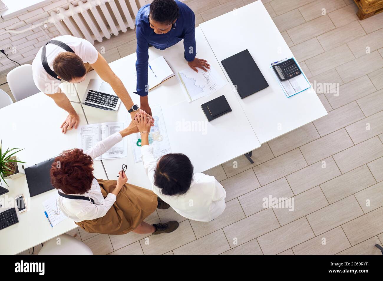 Top view on group of diverse colleagues in formalwear joining hands ...