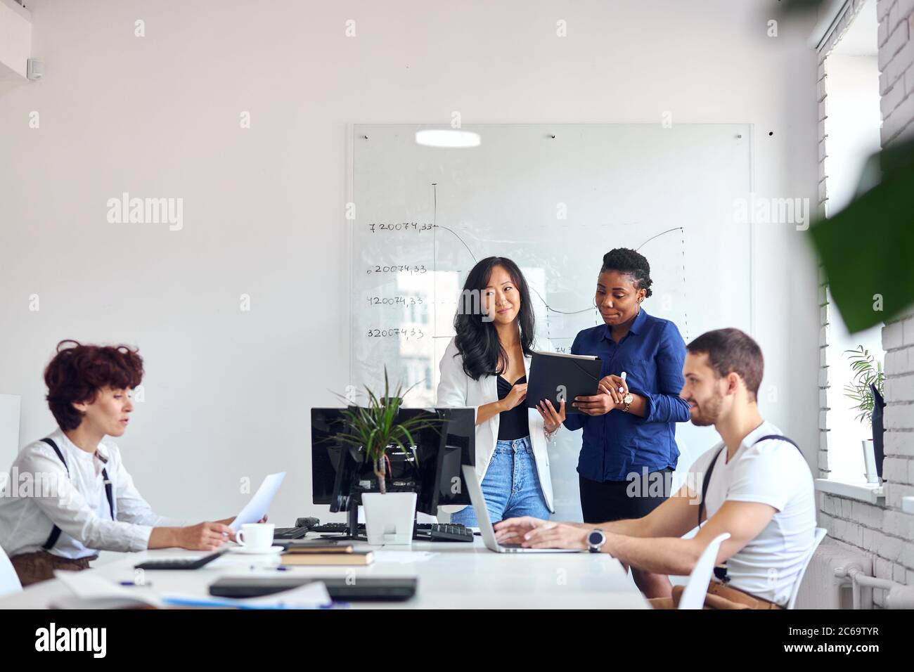 multi-ethnic team listen to presentation of african coach leader ...