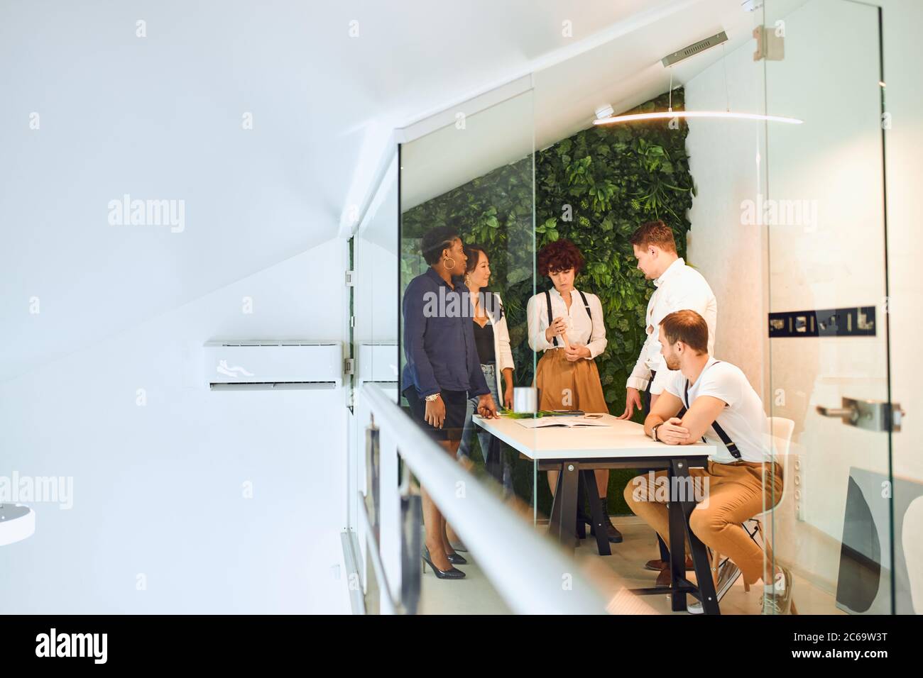 Modern office occupied with young international team of business people ...