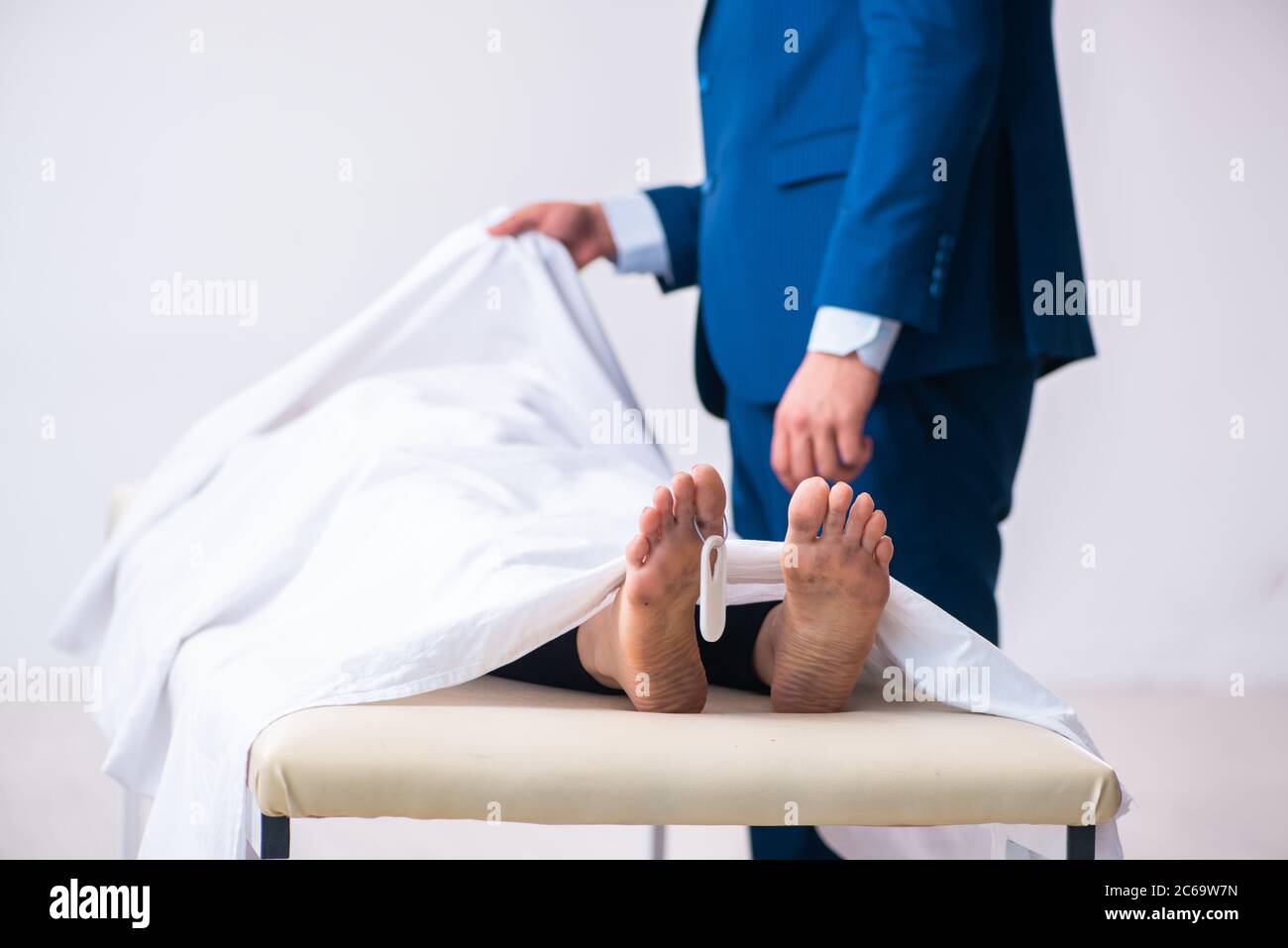 Police coroner examining dead body in morgue Stock Photo - Alamy