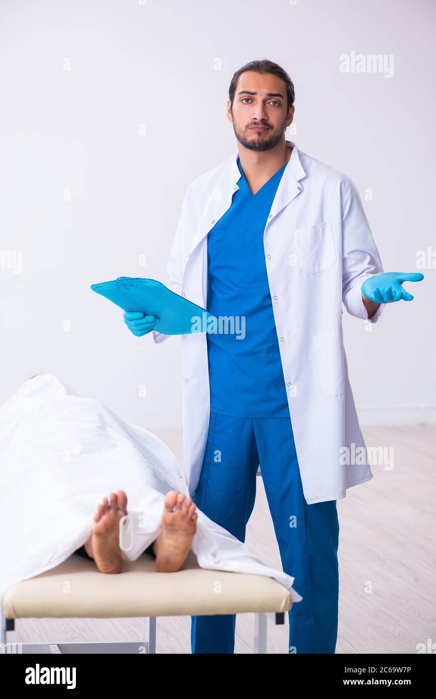 Police coroner examining dead body in morgue Stock Photo - Alamy