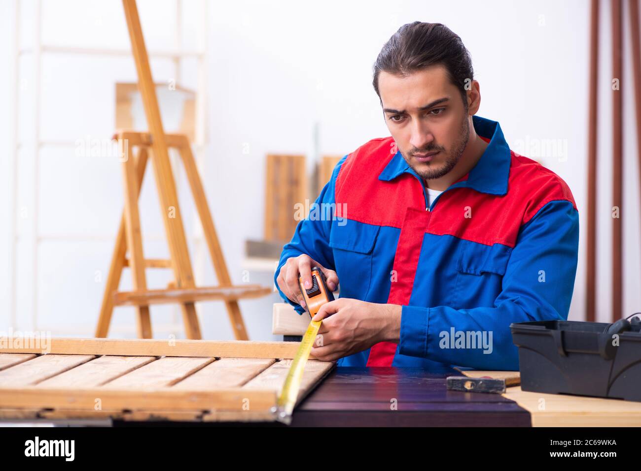Young male contractor working in the workshop Stock Photo - Alamy