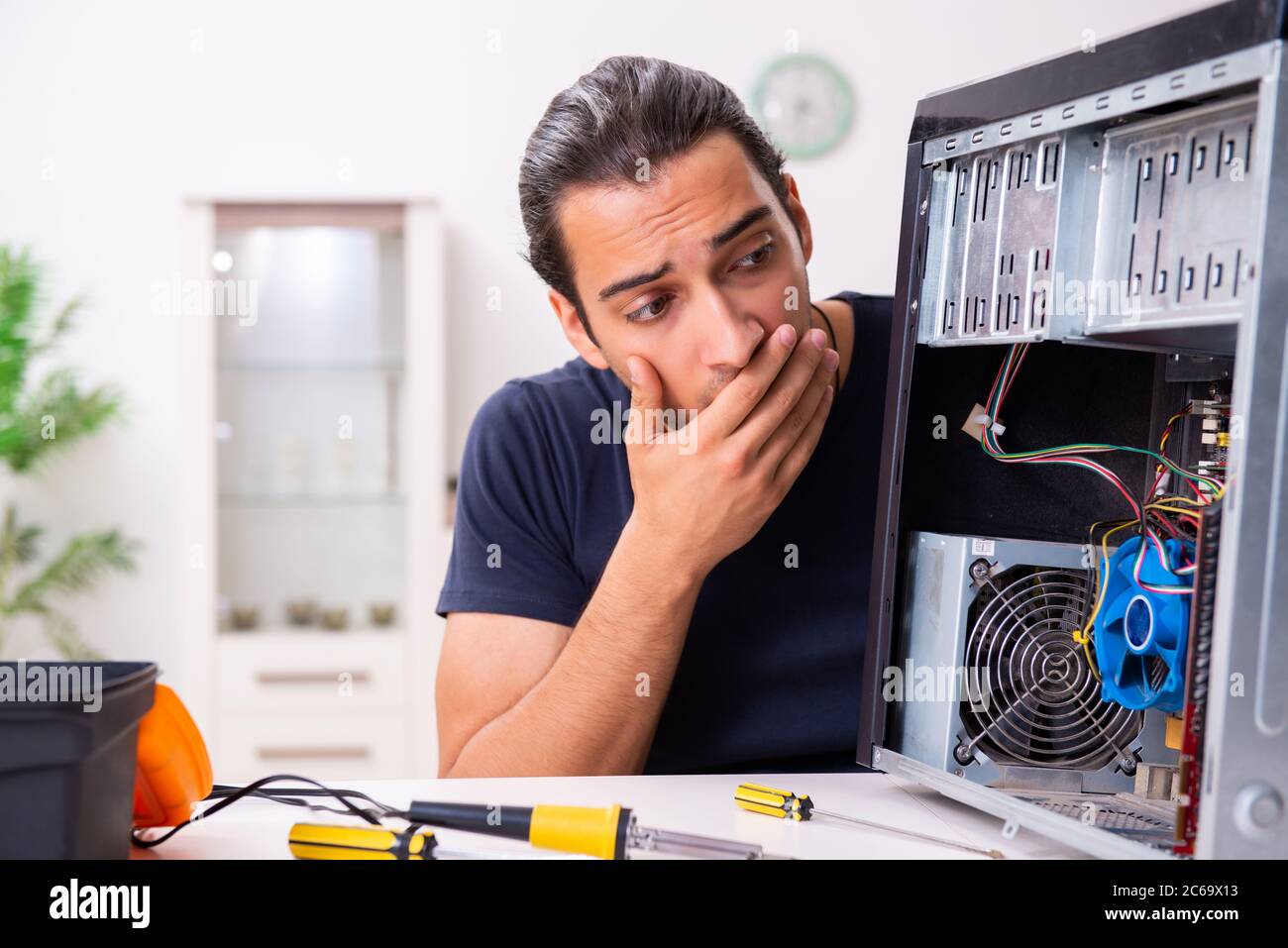 Young man repairing computer at the home Stock Photo - Alamy