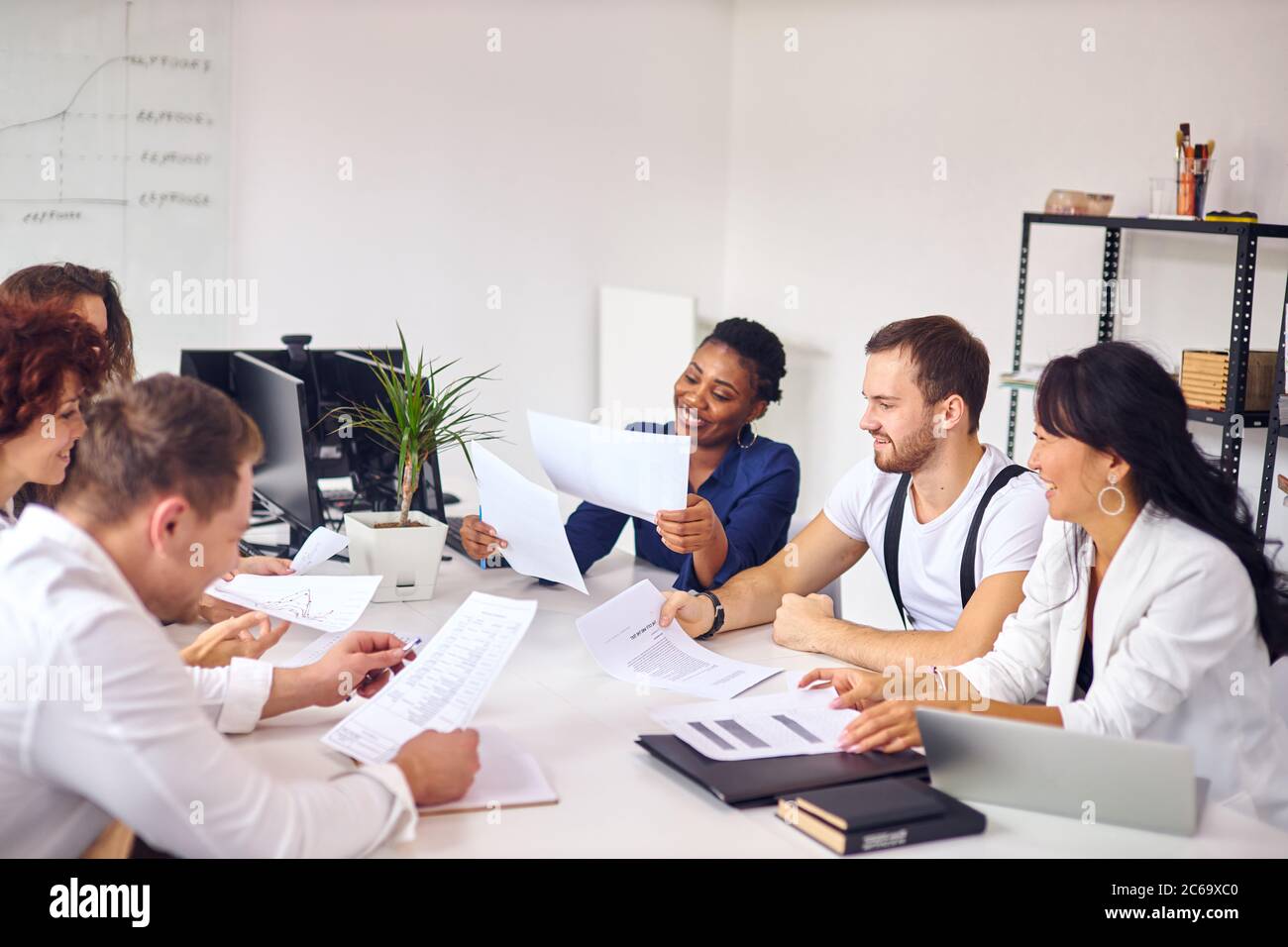 Creation of new business idea by multiethnic group sitting in meeting ...