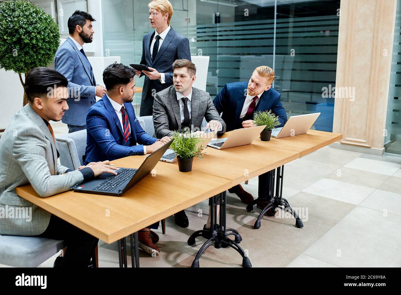 Smart and young men conduct negotiations in business office. Arabic ...