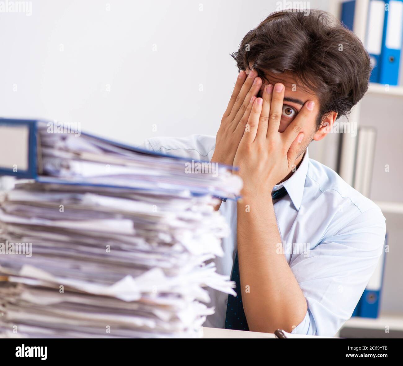 The overloaded busy employee with too much work and paperwork Stock ...