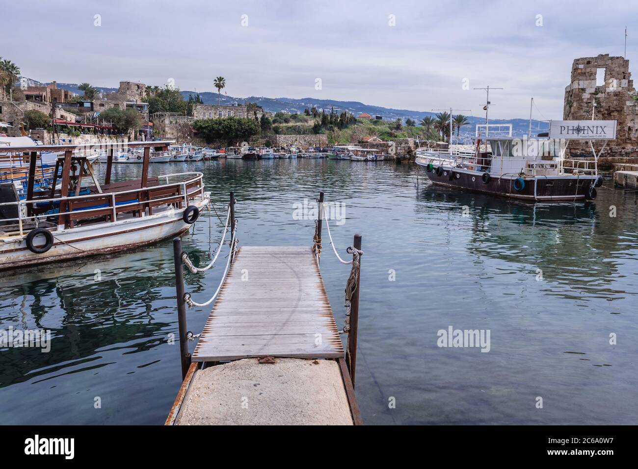 Tourist boat and ramins of ancient port in Byblos, largest city in the ...
