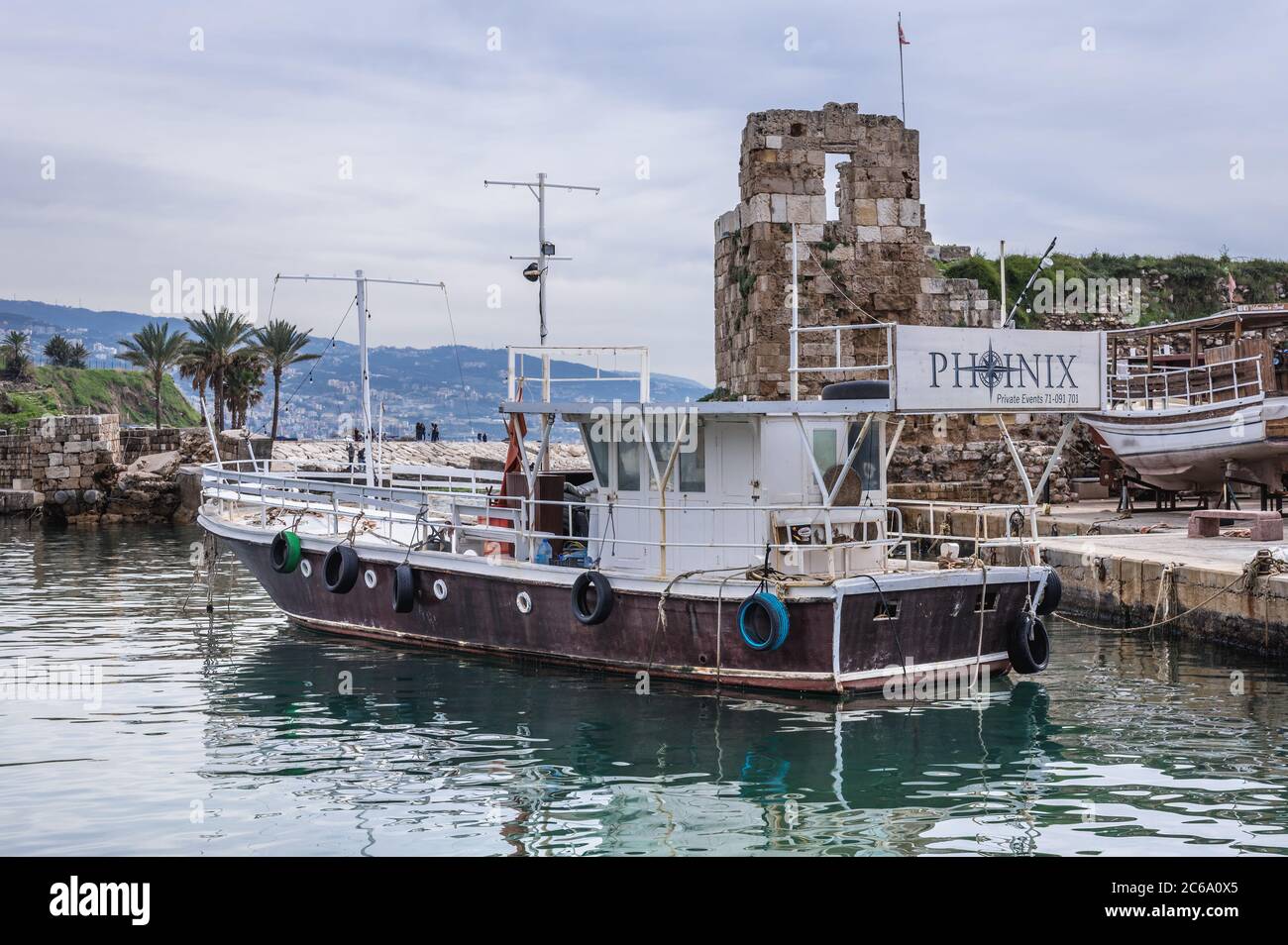 Tourist boat and ramins of ancient port in Byblos, largest city in the ...