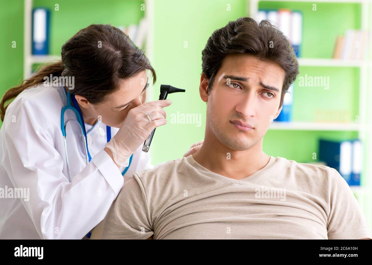 The female doctor checking patient's ear during medical examination ...
