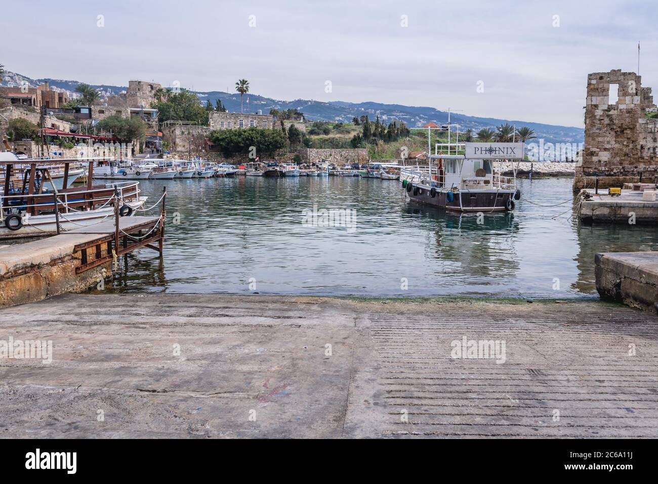 Tourist boat and ramins of ancient port in Byblos, largest city in the ...